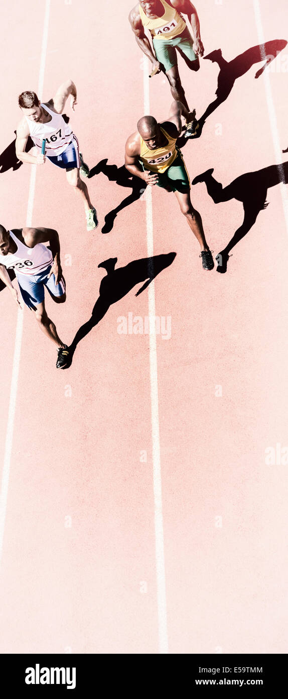 Relay runners racing on track Stock Photo - Alamy