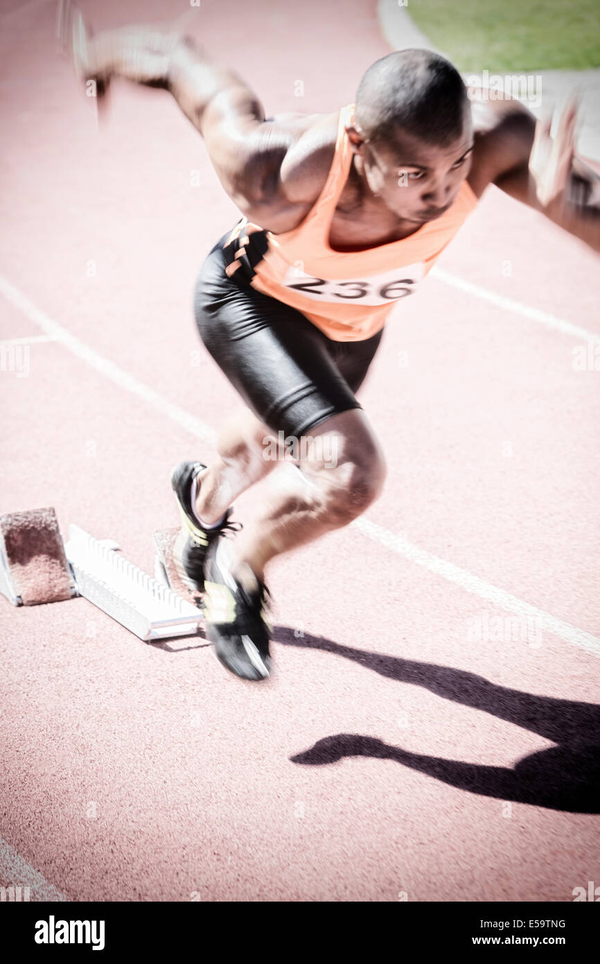 Runner taking off from starting block Stock Photo - Alamy