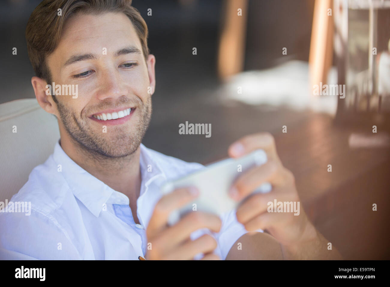Man using cell phone in armchair Stock Photo - Alamy