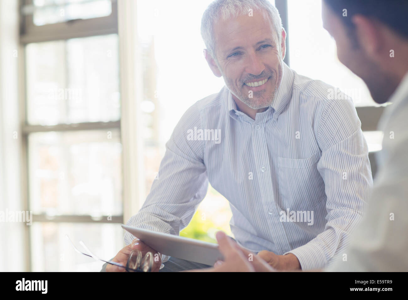 Businessmen laughing together in office Stock Photo - Alamy