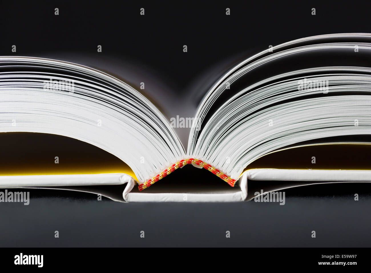 An open hardbacked book with black background Stock Photo - Alamy