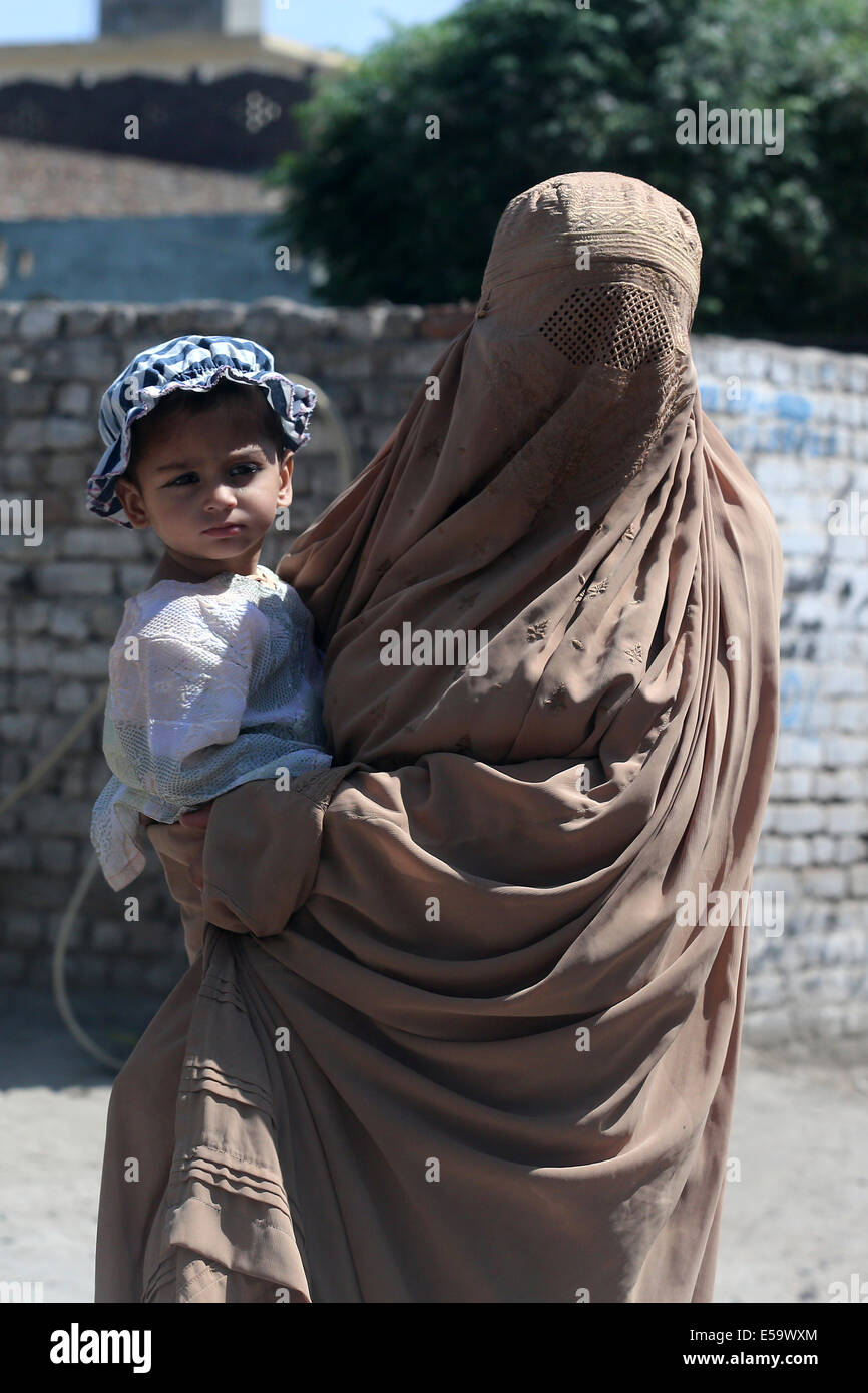 Afghan refugee woman with her child in a refugee camp in Islamabad ...