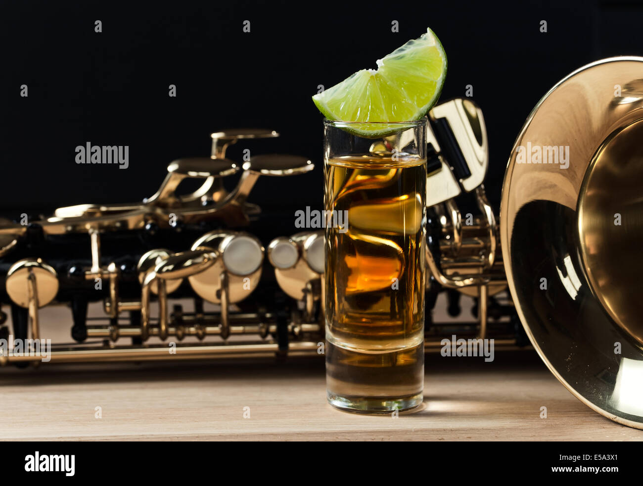 saxophone and tequila with lime on wooden table Stock Photo - Alamy
