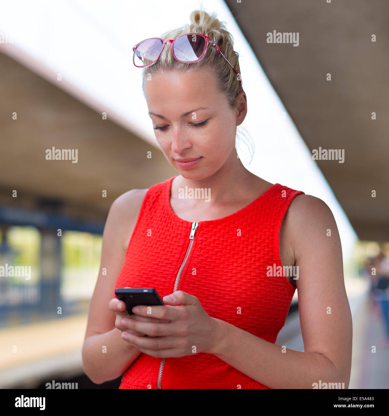 Young woman on platform of railway station Stock Photo - Alamy