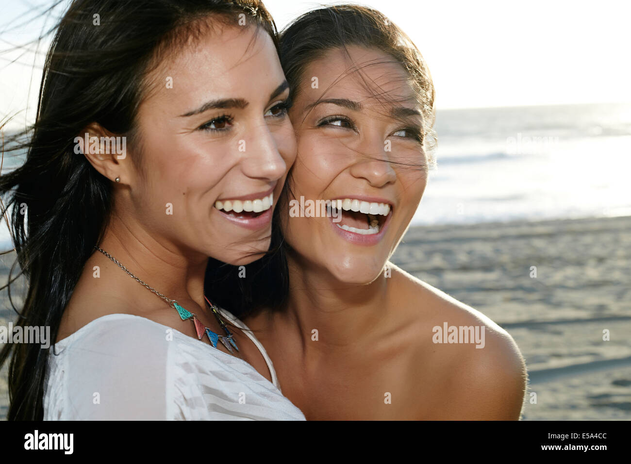 Women smiling together on beach Stock Photo - Alamy