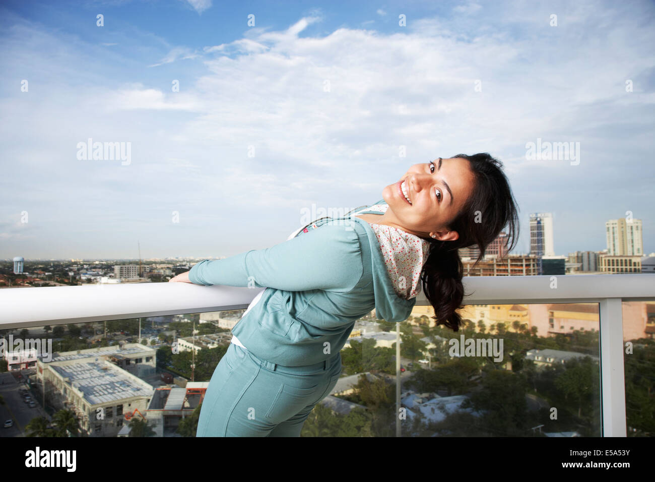 Hispanic woman on balcony overlooking urban cityscape Stock Photo - Alamy