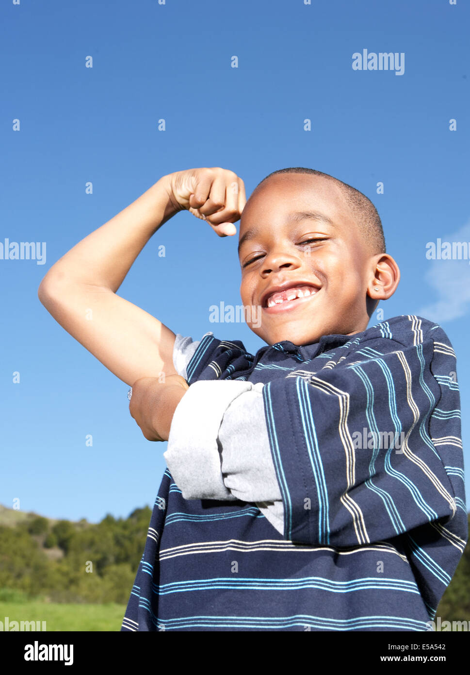 African American boy flexing his muscles Stock Photo - Alamy