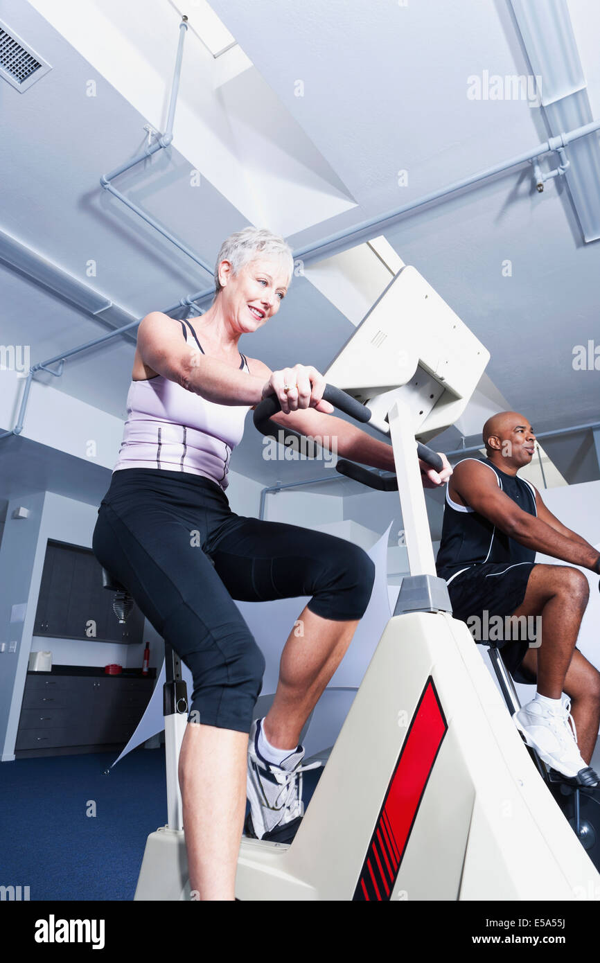 People using exercise machines in gym Stock Photo - Alamy