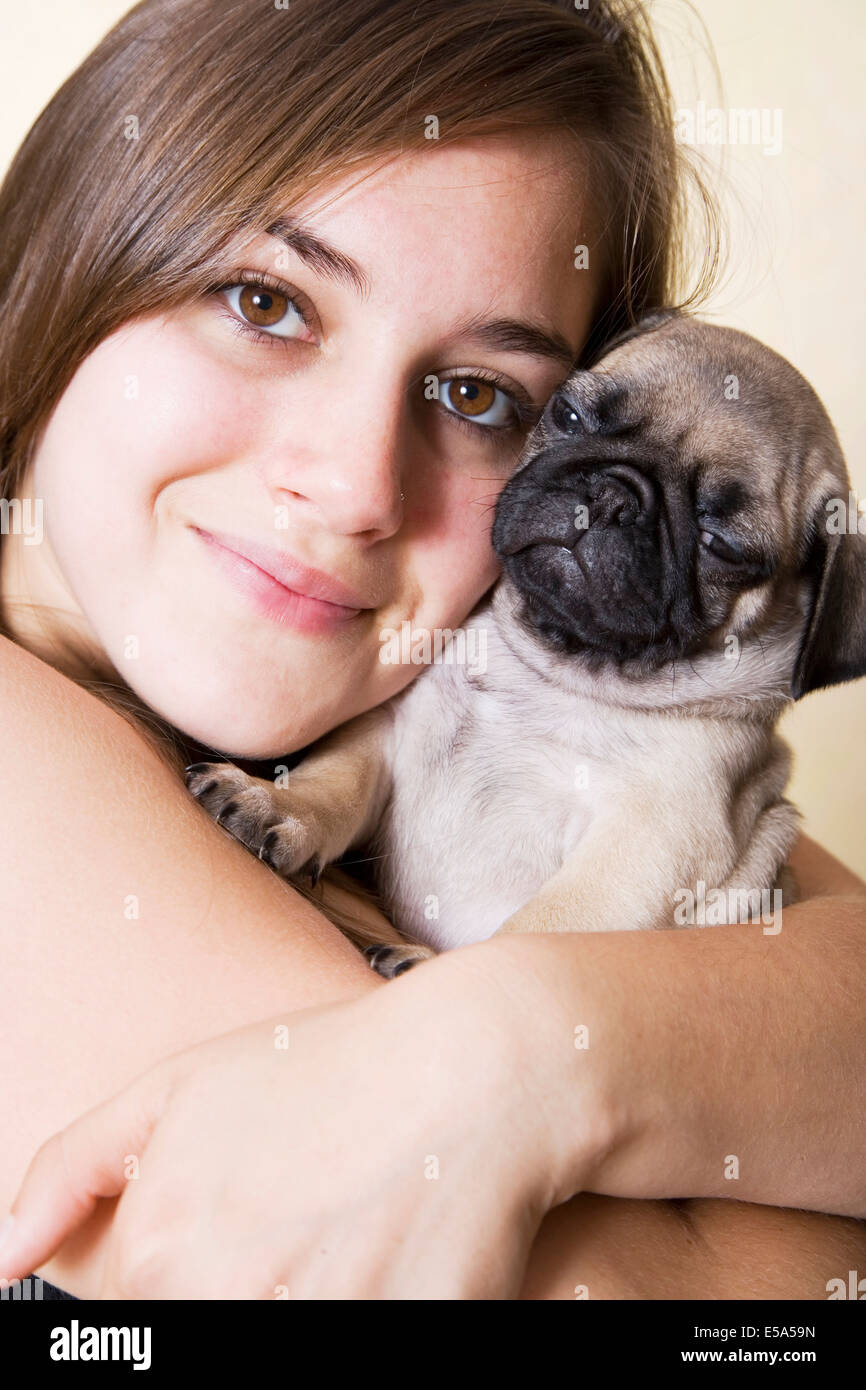 Mixed race woman hugging pug Stock Photo - Alamy