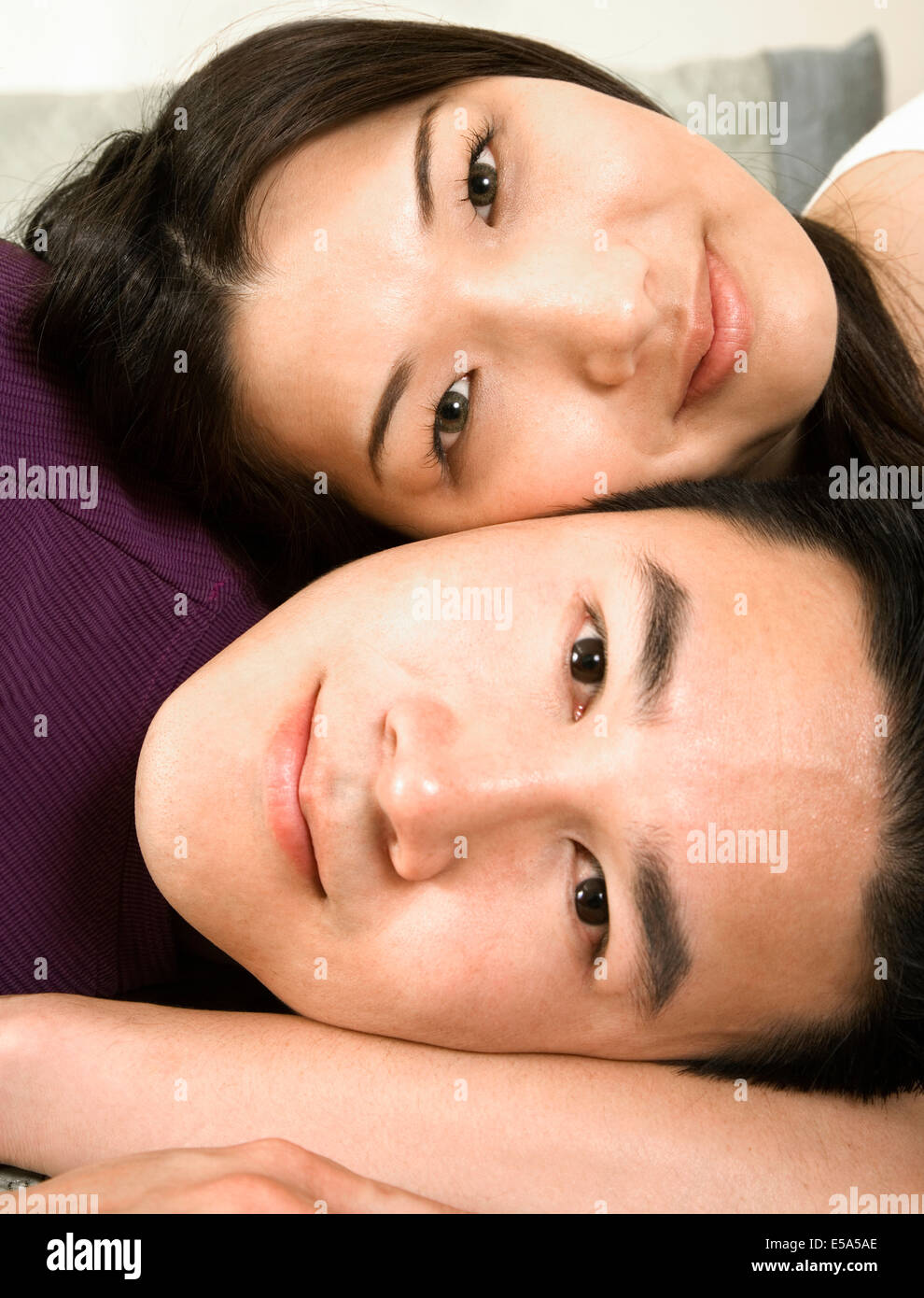Chinese couple relaxing on bed Stock Photo - Alamy