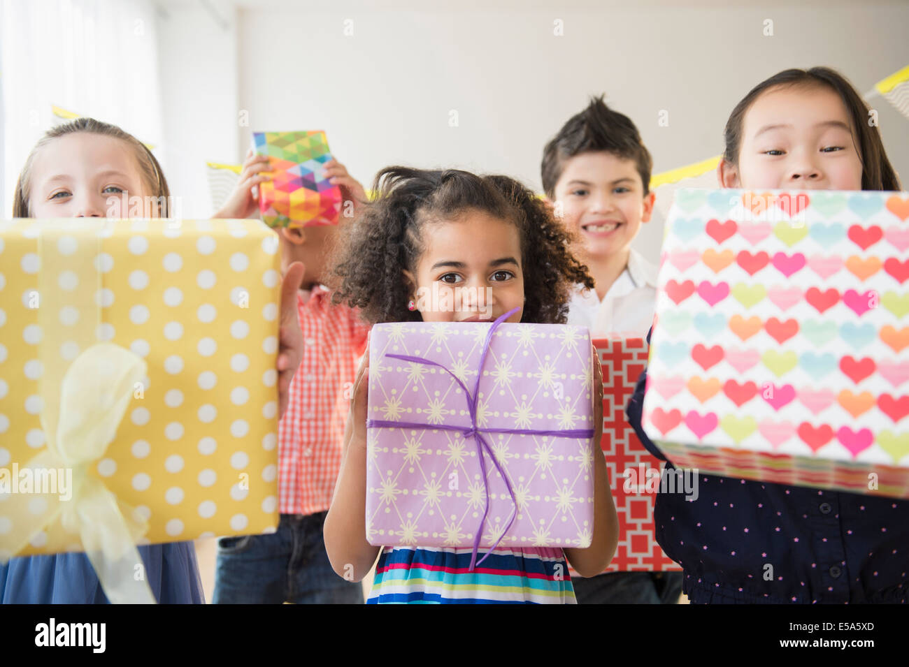 Children holding birthday presents at party Stock Photo - Alamy