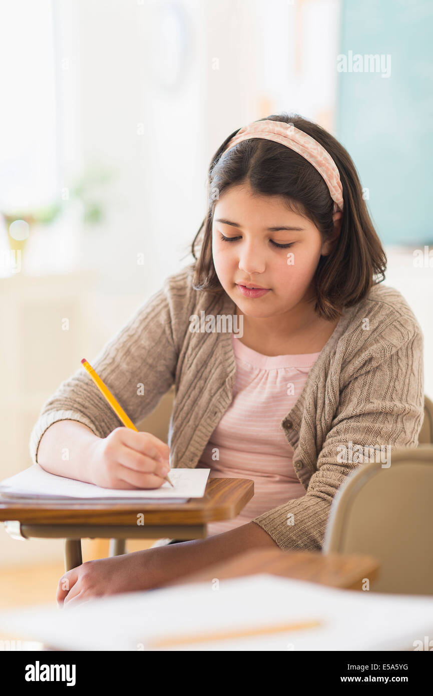 Hispanic girl taking notes in classroom Stock Photo - Alamy