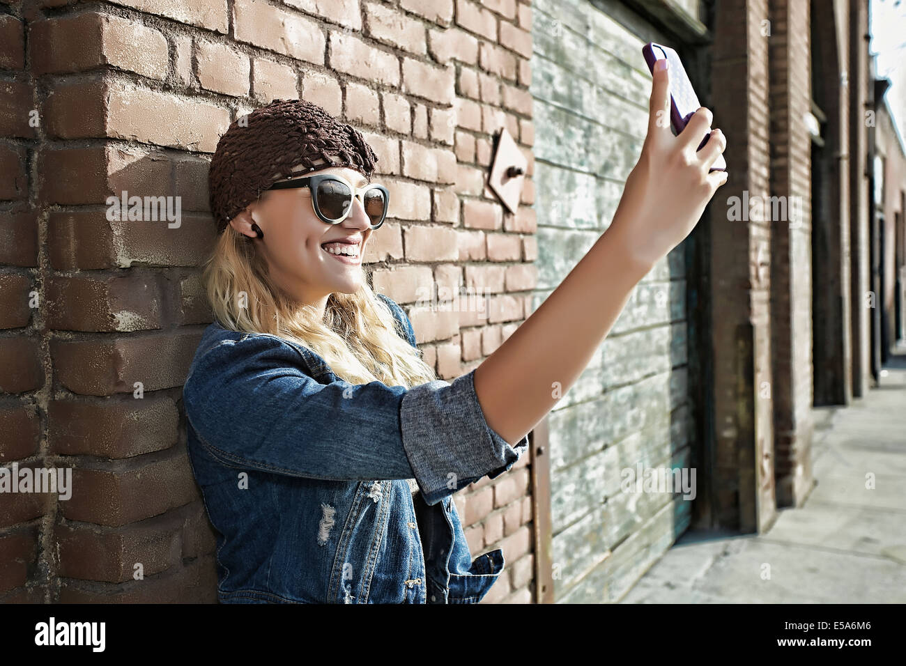 Woman taking picture of herself on city street Stock Photo - Alamy