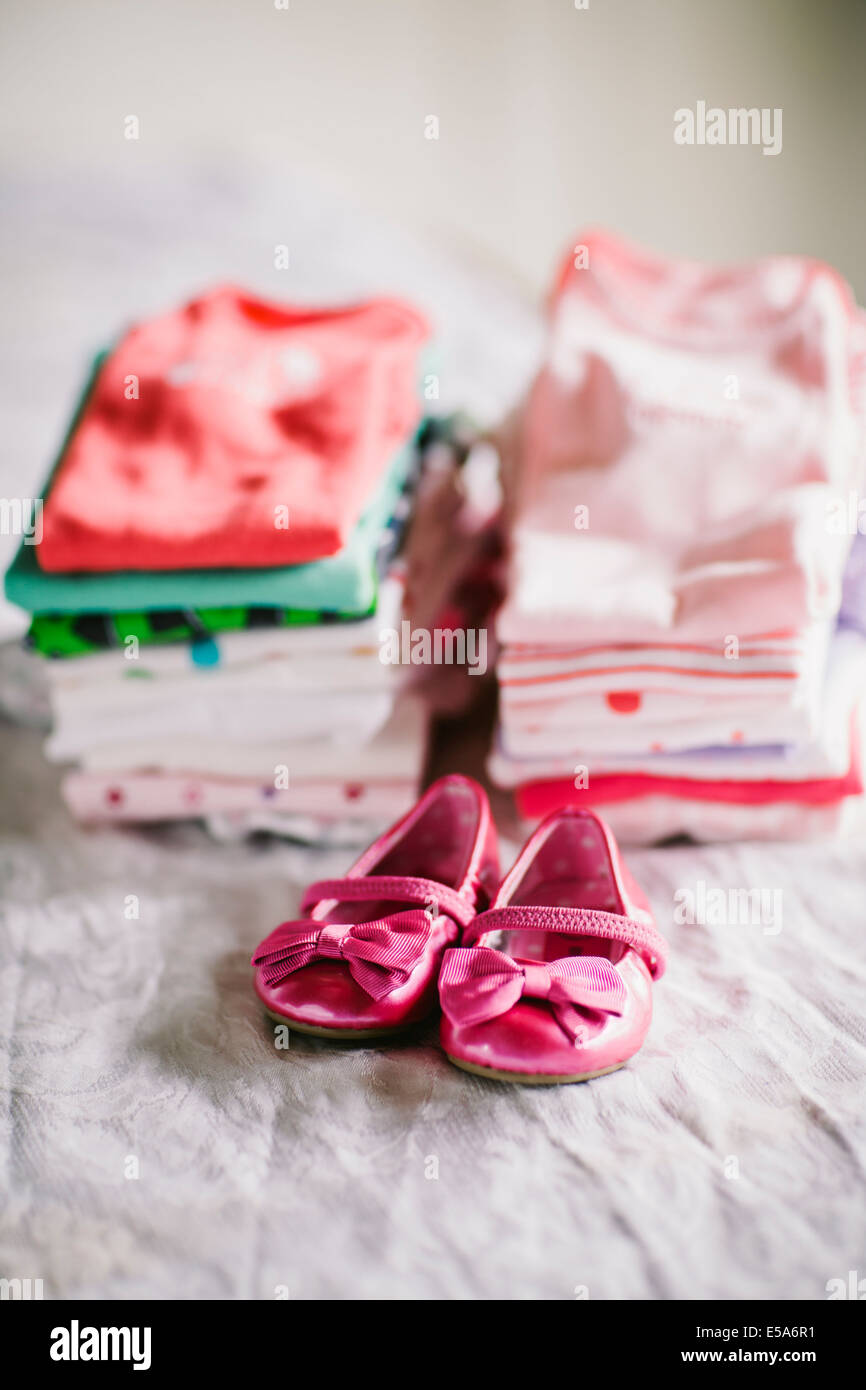 Stack of baby clothes with shoes Stock Photo - Alamy