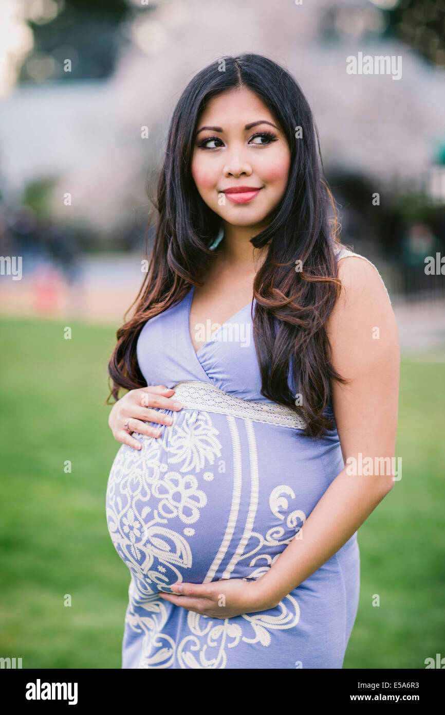 Asian woman holding her pregnant belly Stock Photo - Alamy