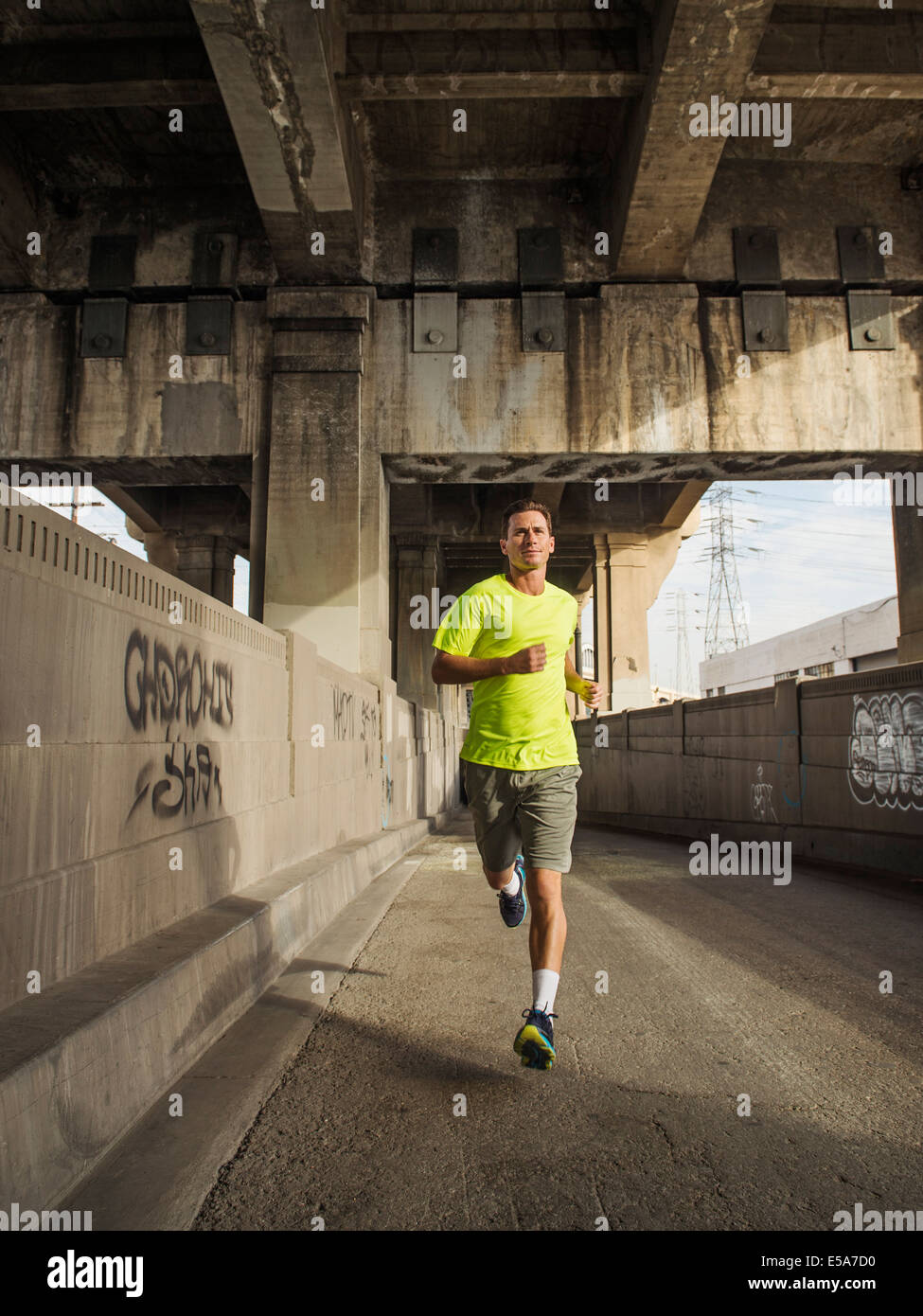 Caucasian man running in urban tunnel Stock Photo - Alamy