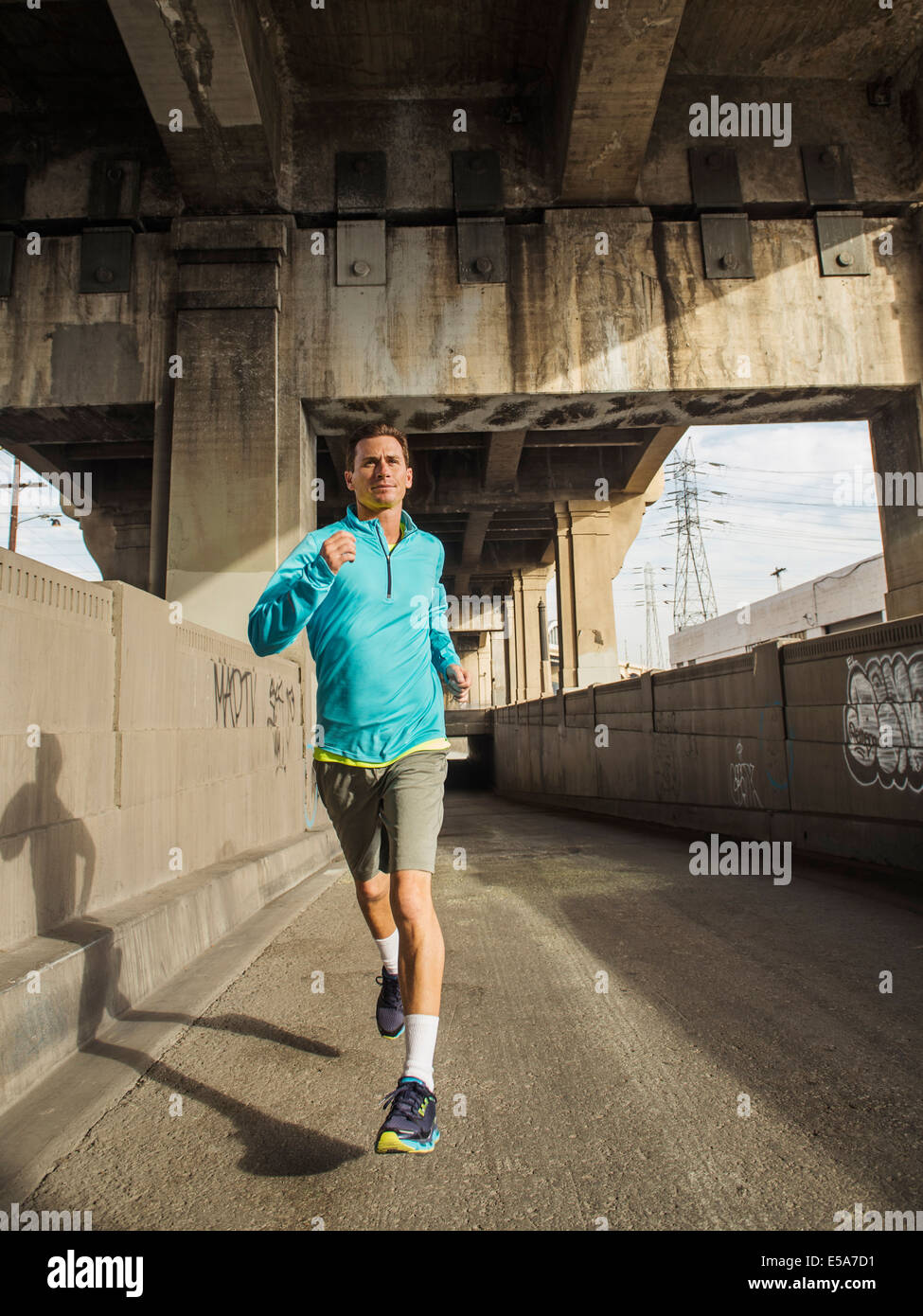 Caucasian man running in urban tunnel Stock Photo - Alamy