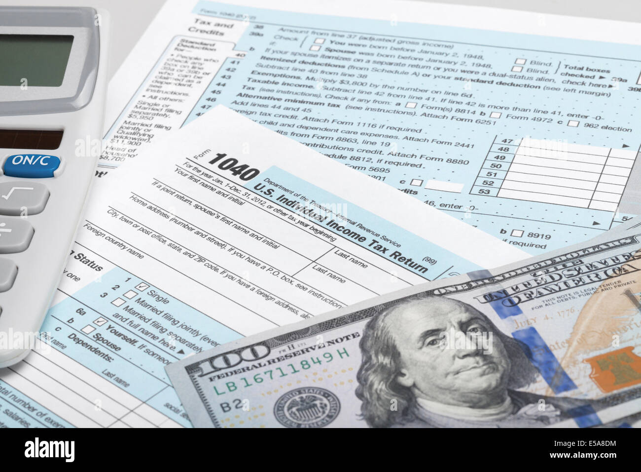 USA Tax Form 1040 with calculator and 100 US dollar bills Stock Photo ...