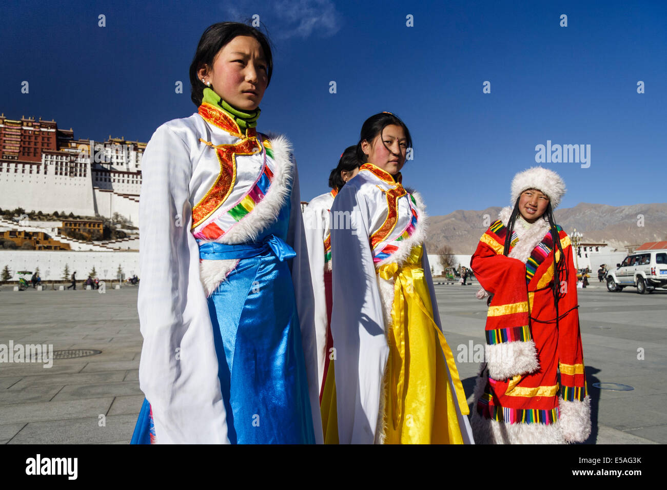 Tibetan girls in traditional dress by the Potala palace. Lhasa, Tibet ...