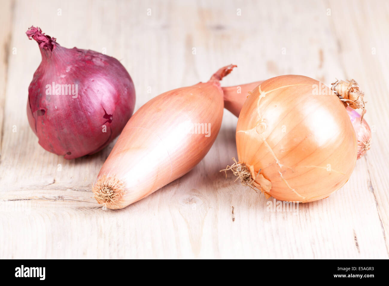A group of onions on wood table Stock Photo - Alamy