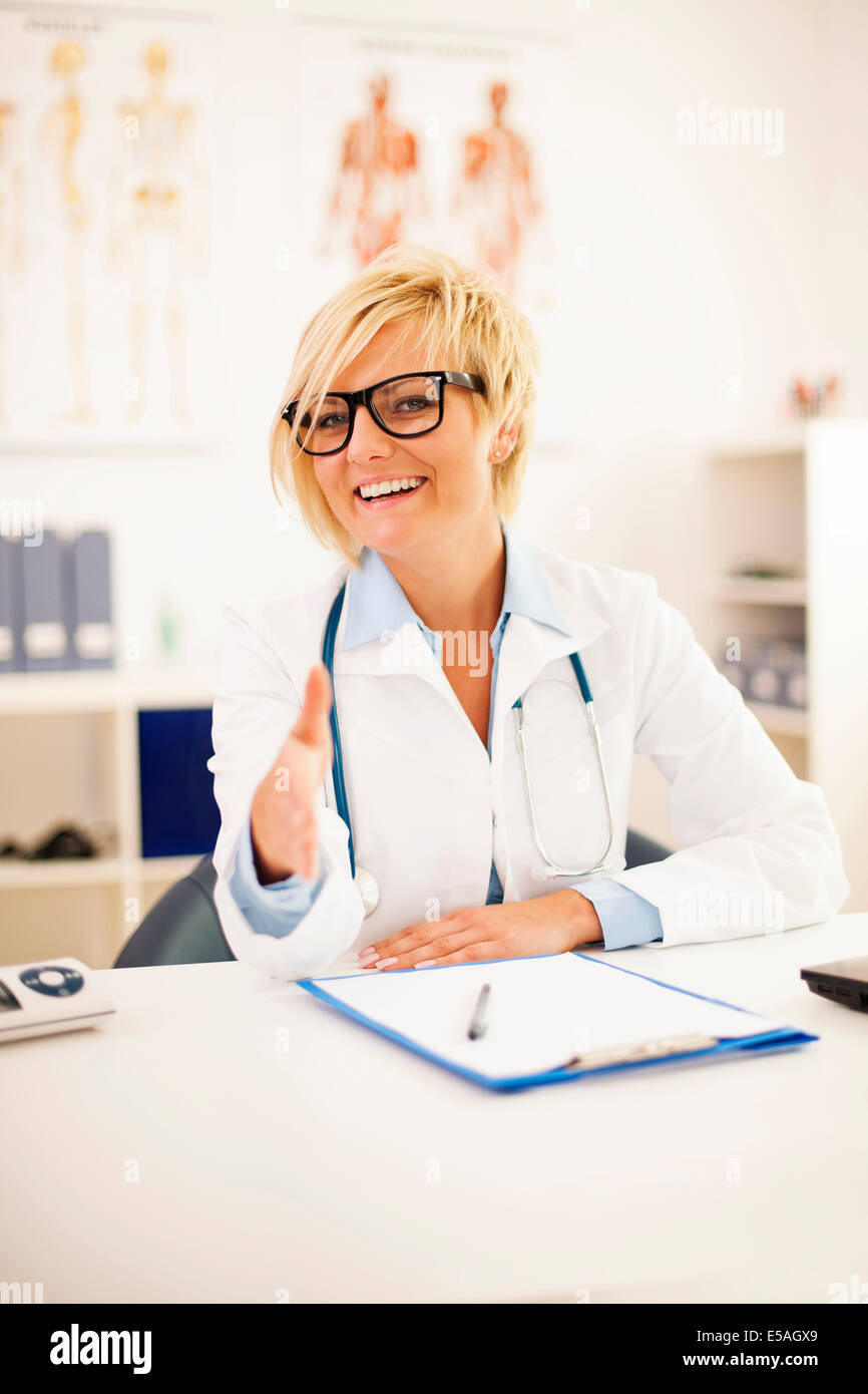 Portrait of smiling female doctor offering a handshake, Debica, Poland ...