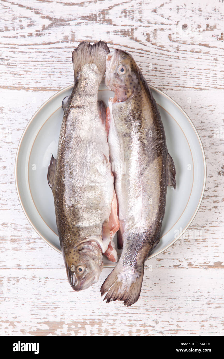 raw whole trout in the bowl on wooden table Stock Photo - Alamy