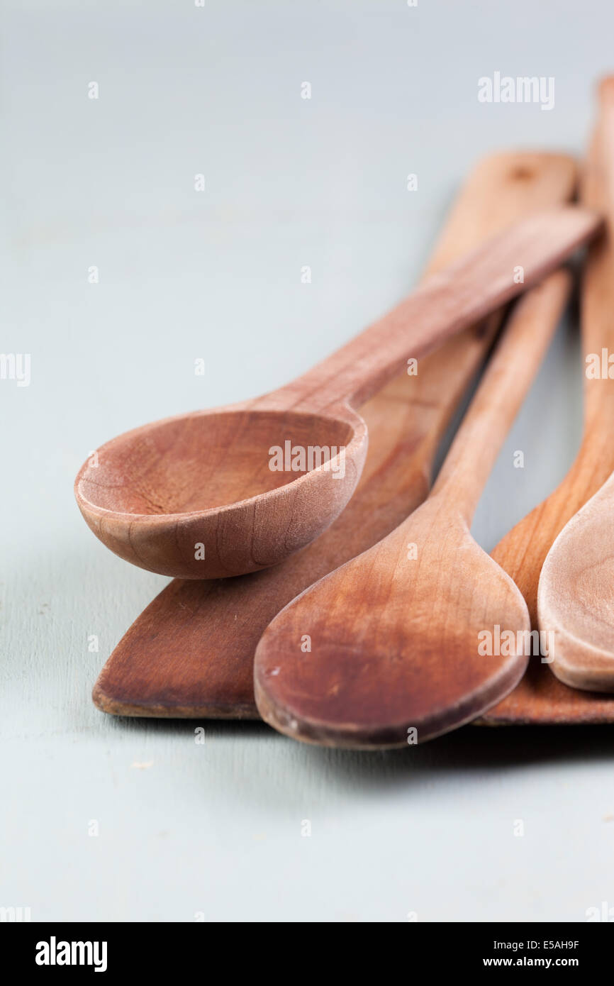 used wooden spoons on light blue background Stock Photo - Alamy