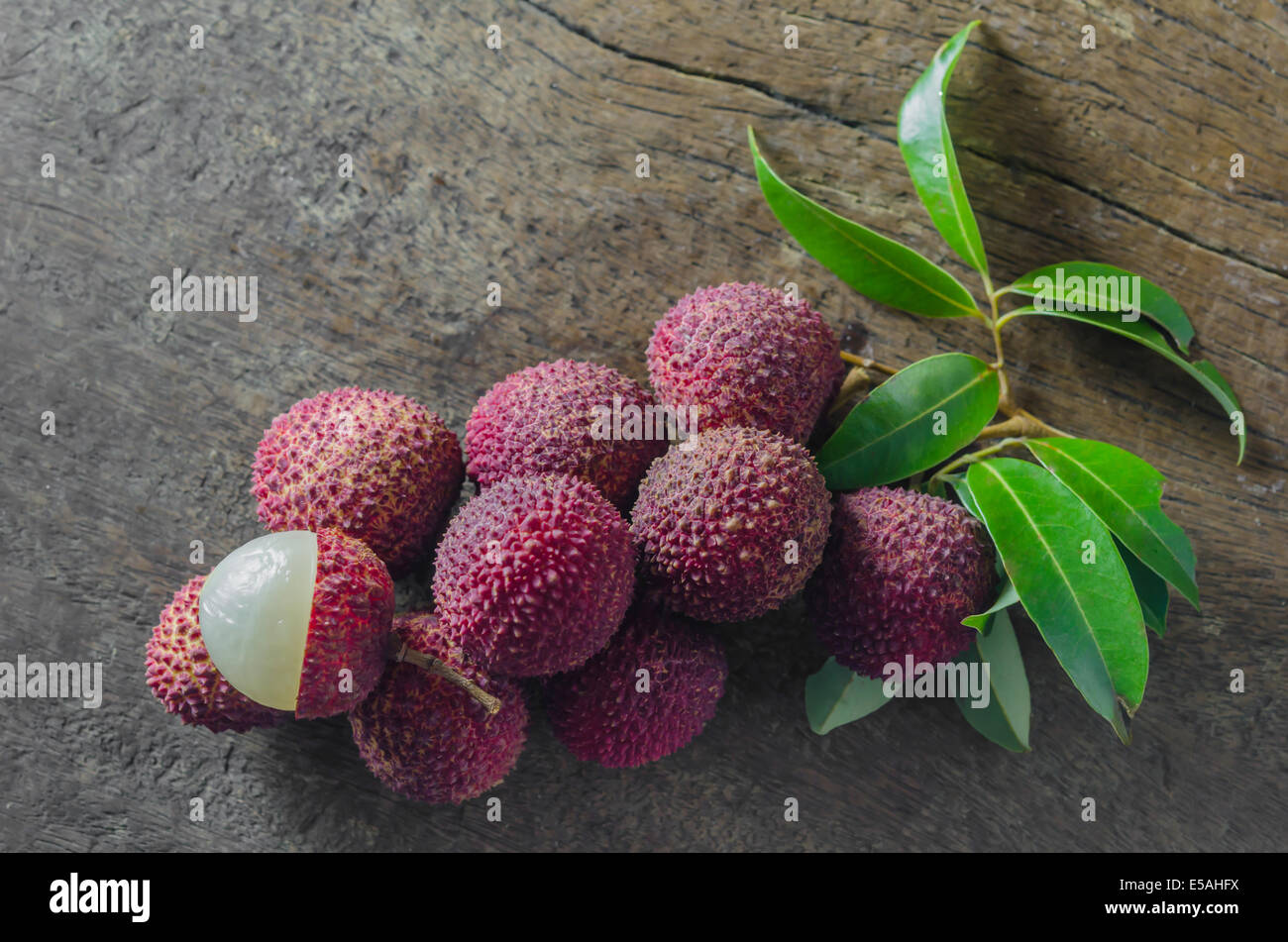 Lychee with leaves on a wooden table Stock Photo - Alamy