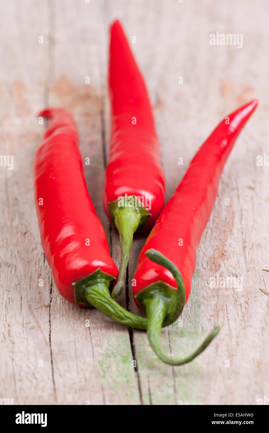three red chilli peppers on the wood Stock Photo - Alamy