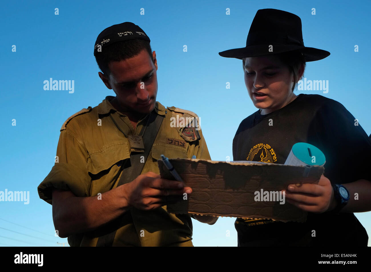 A member of Habad religious movement helps an Israeli soldier to read a ...