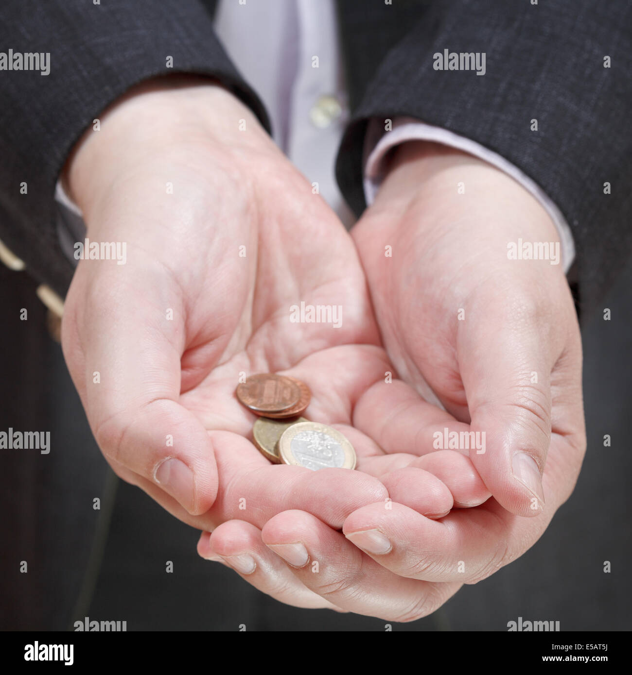 little of coins in businessman's handful close up Stock Photo - Alamy