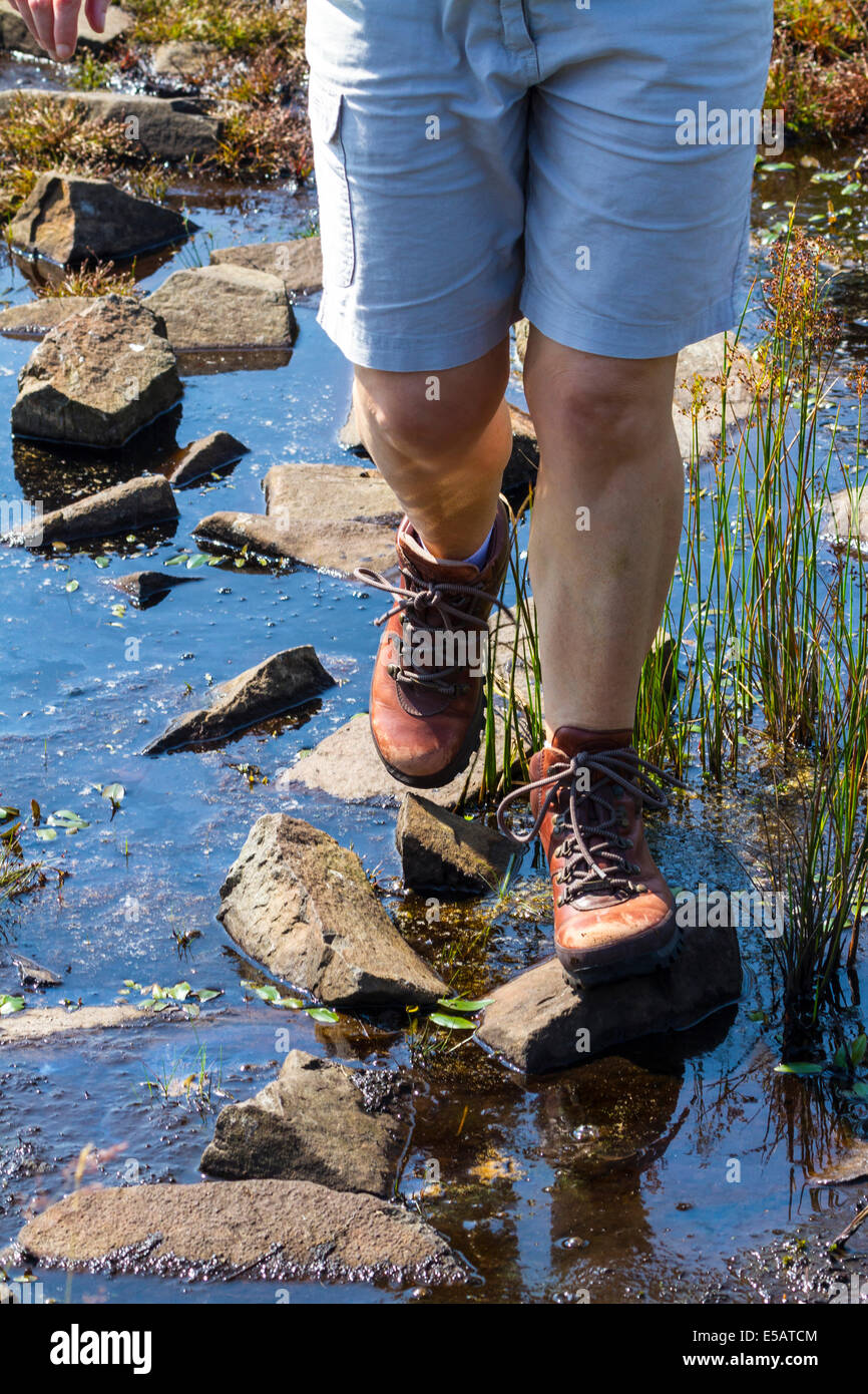 A Woman Hiker using Stepping Stones to cross a stream at The Grey Man's ...