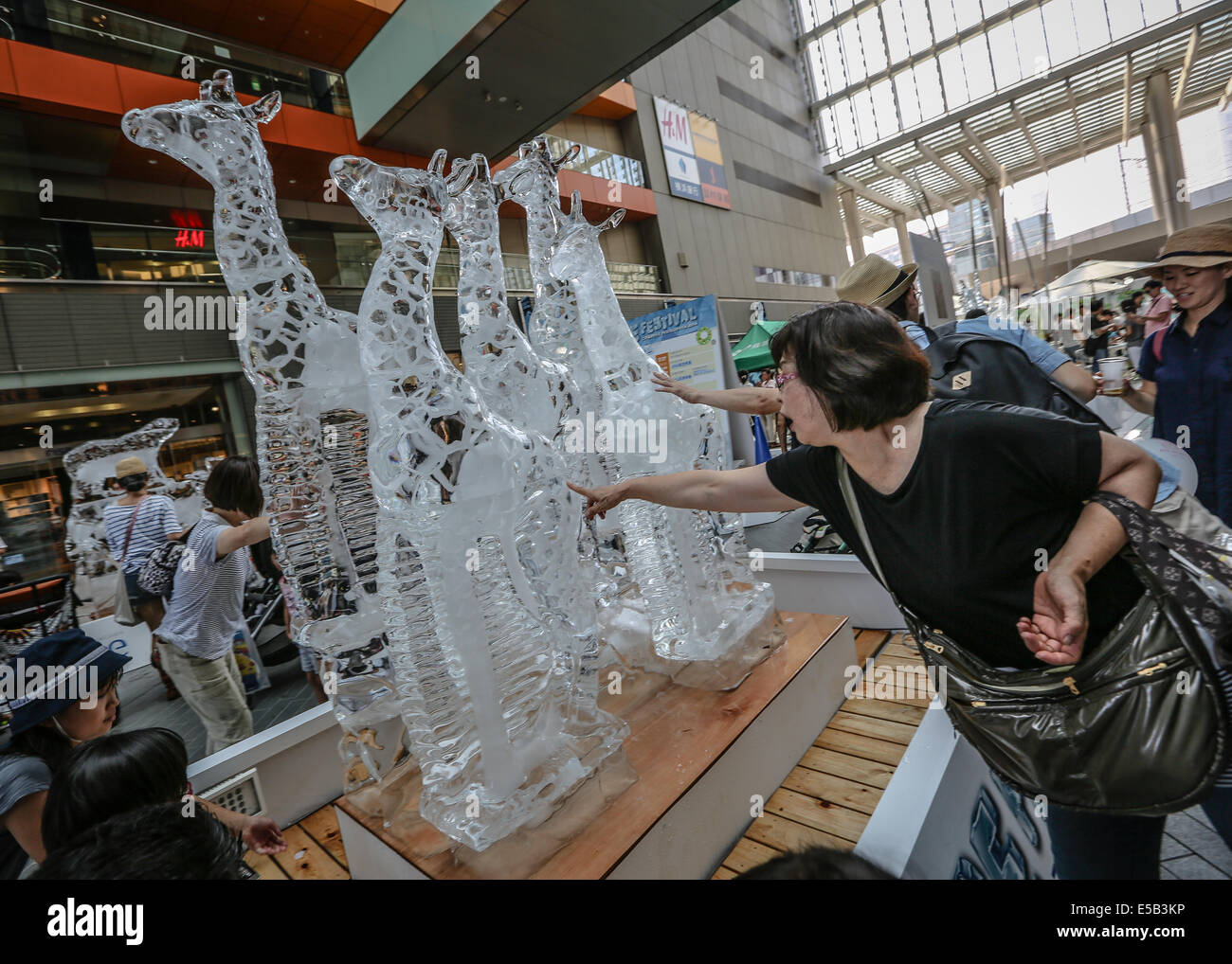 Tokyo, Japan. 26th July, 2014. Visitors touch a ice sculpture of ...