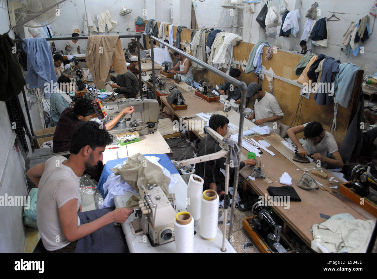 Peshawar. 26th July, 2014. Tailors stitch clothes for the upcoming Eid ...