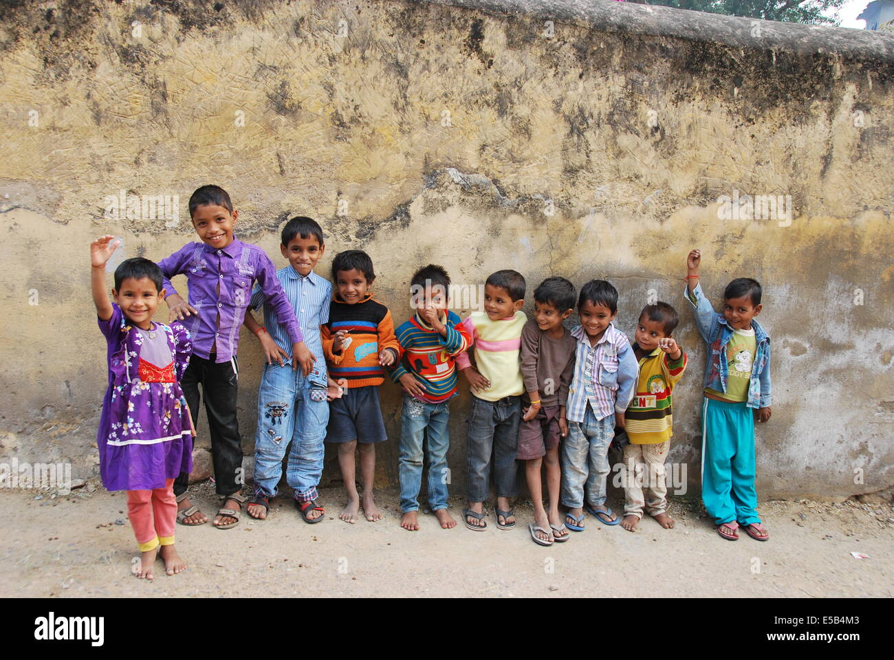 India. Rajasthan. Village children against rough wall.One girl. Nine ...