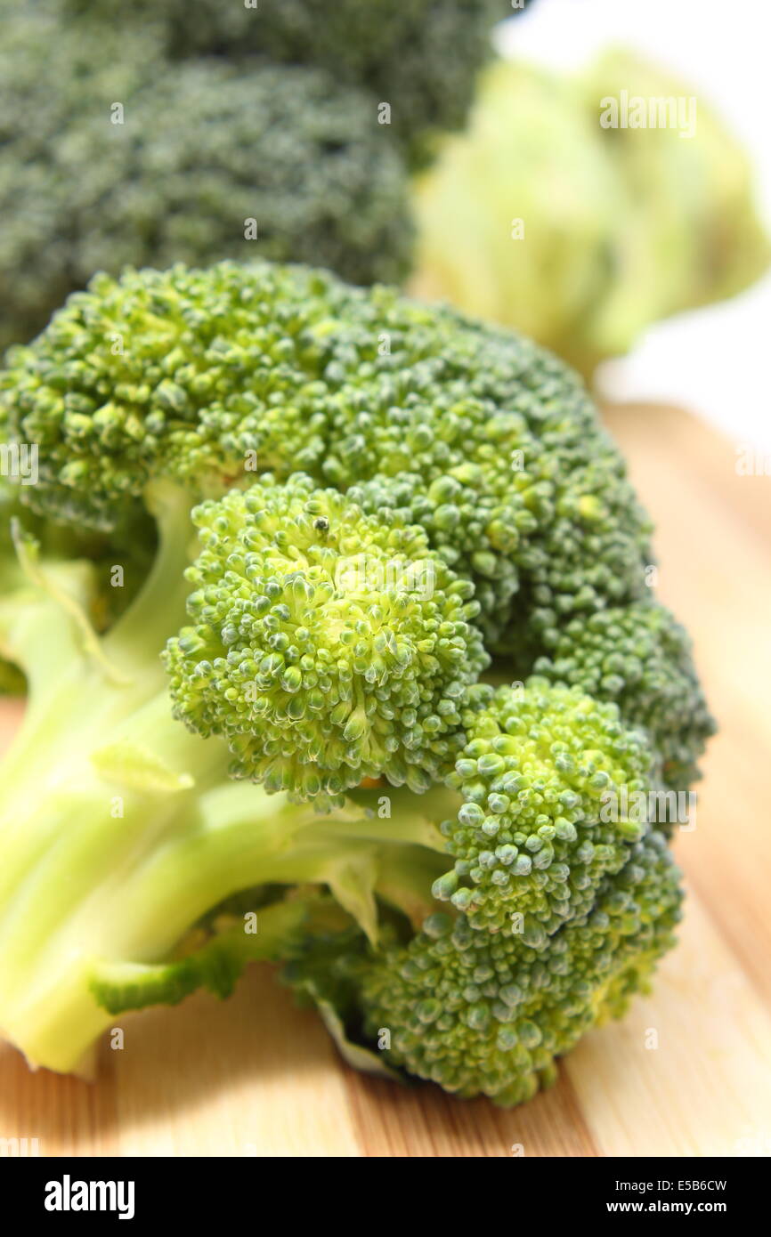 Portion of fresh raw green broccoli and whole vegetable in background ...