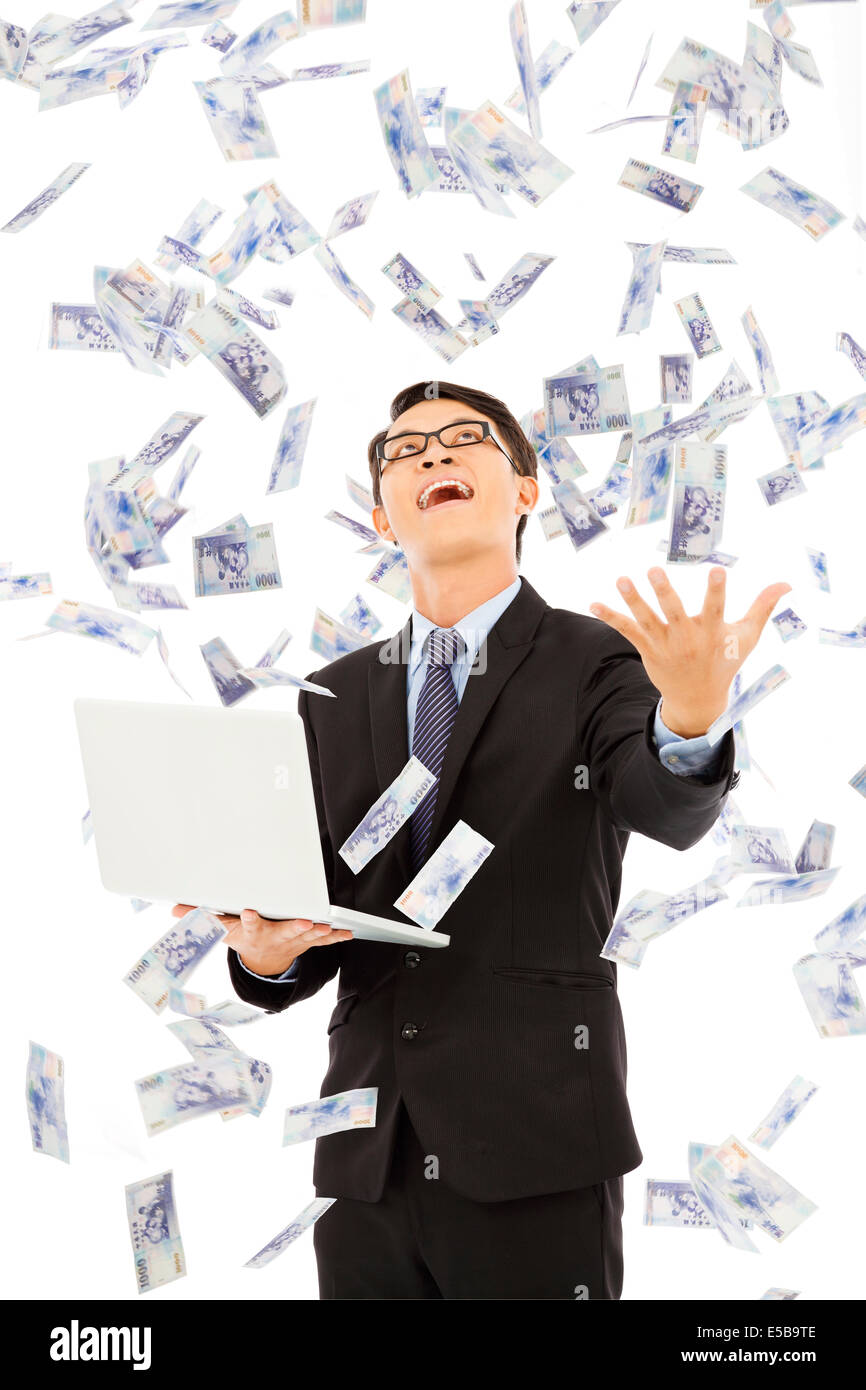 happy business man holding a laptop and catching money Stock Photo - Alamy