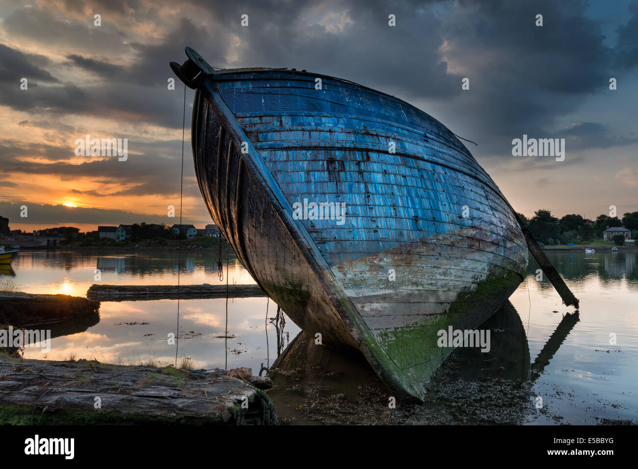 An old abandoned wooden fishing boat on the shore at Hooe lake in ...