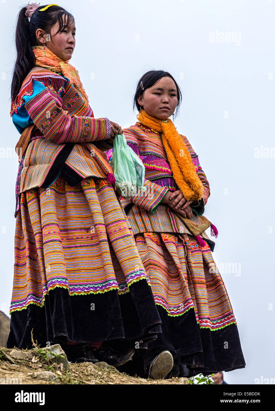 Two young Hmong women show and wait at Sunday market in colorful ...