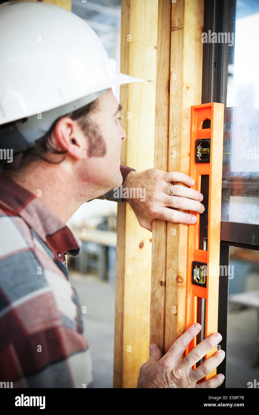 Construction carpenter using level to check his work Stock Photo - Alamy