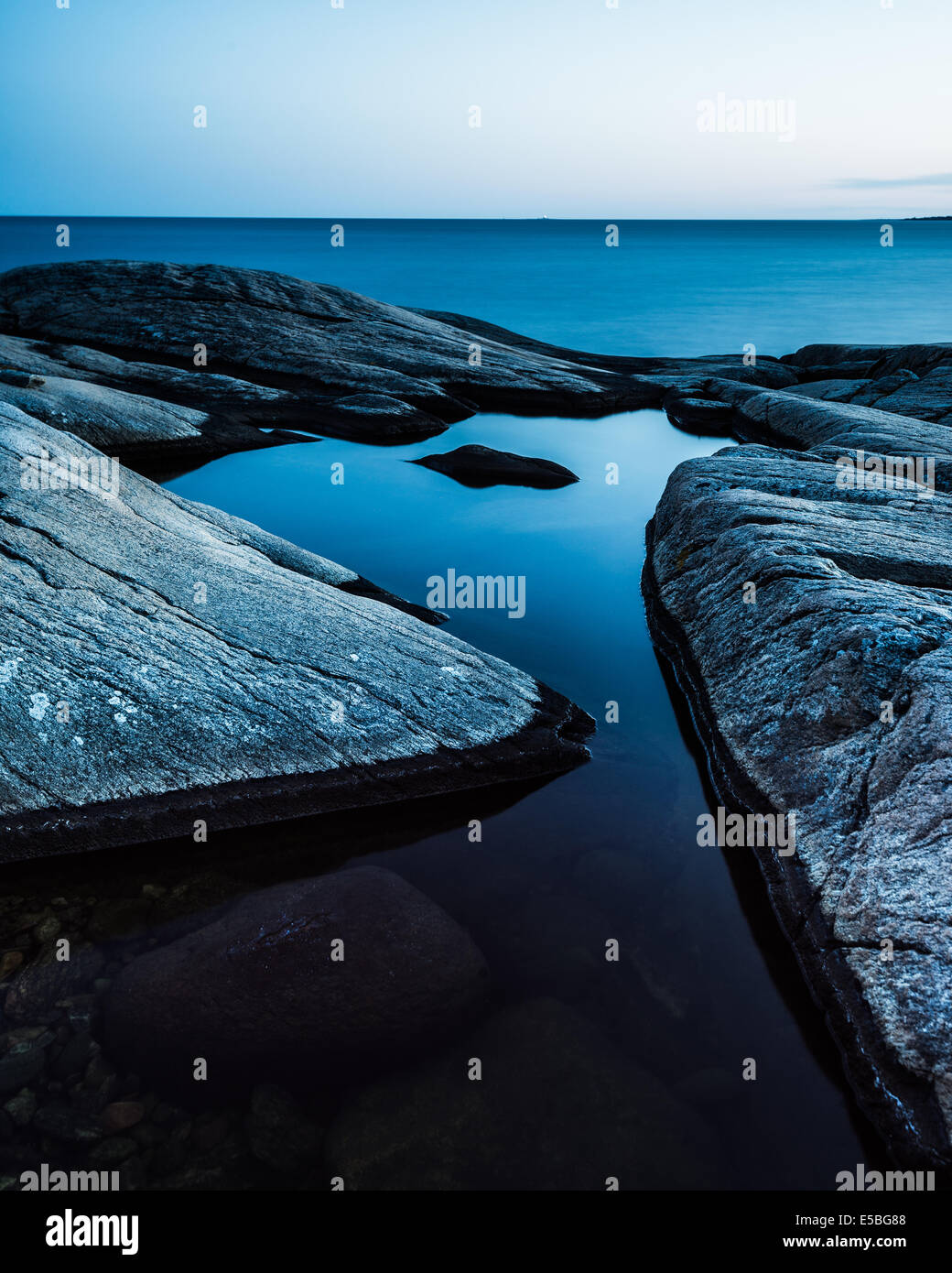 Rocky coast with blue sky and blue sea Stock Photo - Alamy