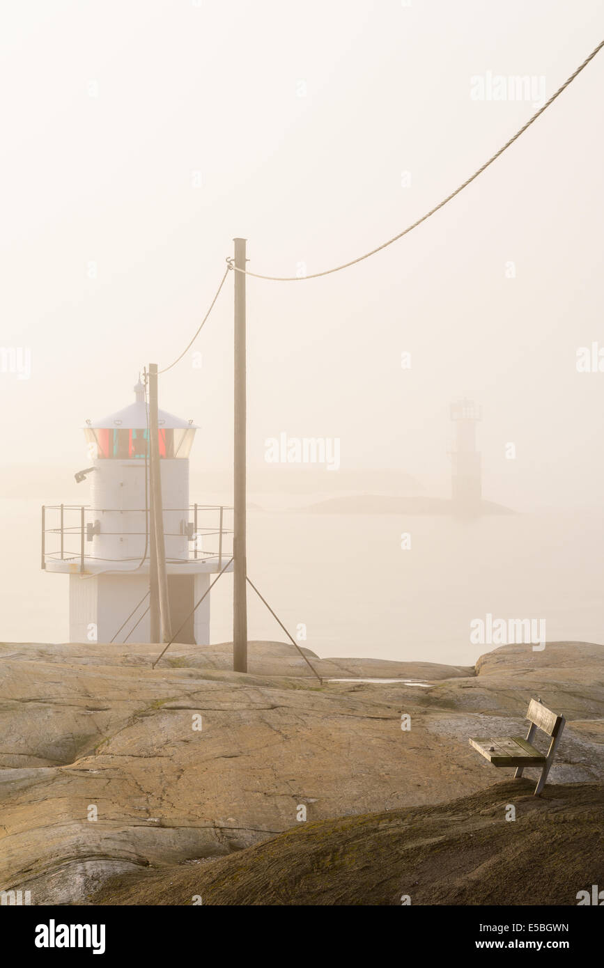 Lighthouse at coast in mist Stock Photo - Alamy