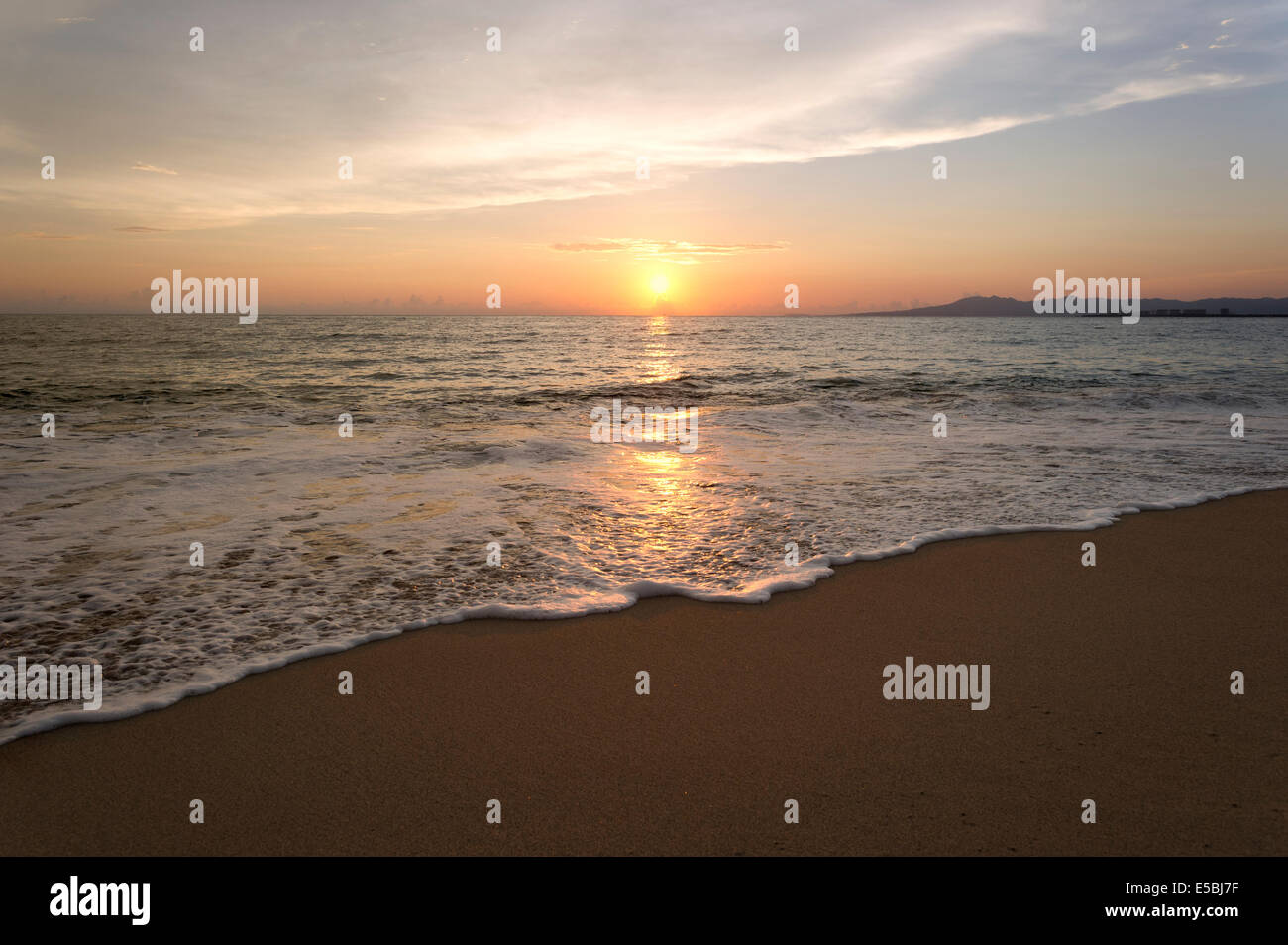 A serene sunset with a closeup of the surf line slowly rolling in Stock ...