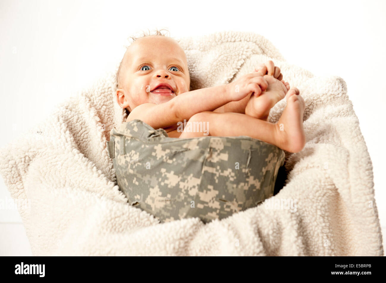 Cute baby sitting in an army helmet Stock Photo - Alamy