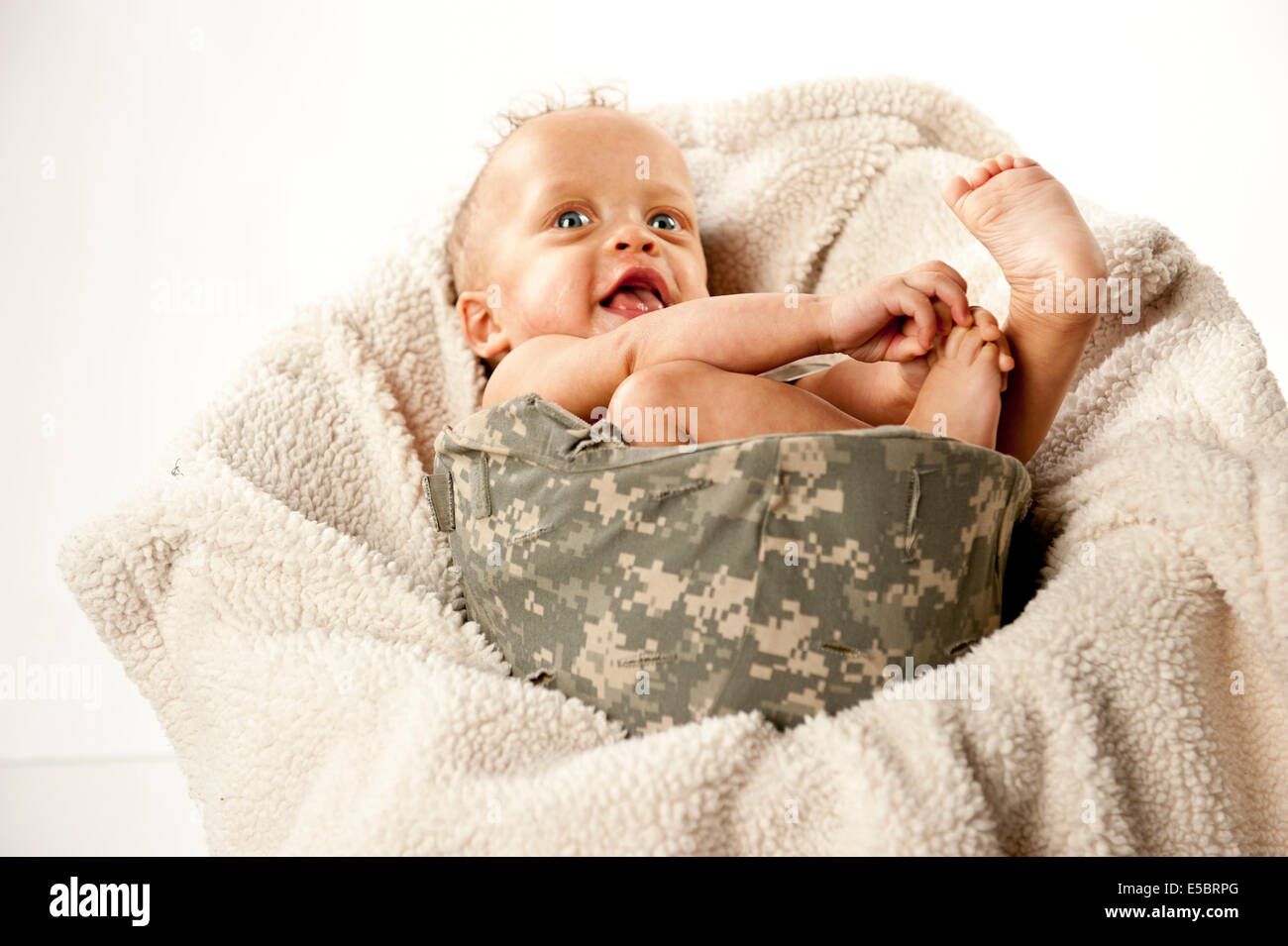 Cute baby sitting in an army helmet Stock Photo - Alamy