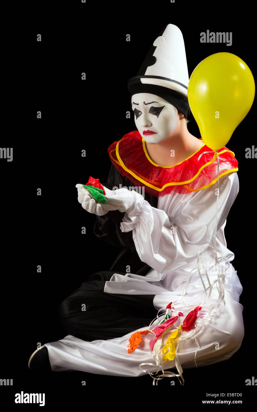 Crying pierrot clown holding exploded balloons in his hand Stock Photo ...