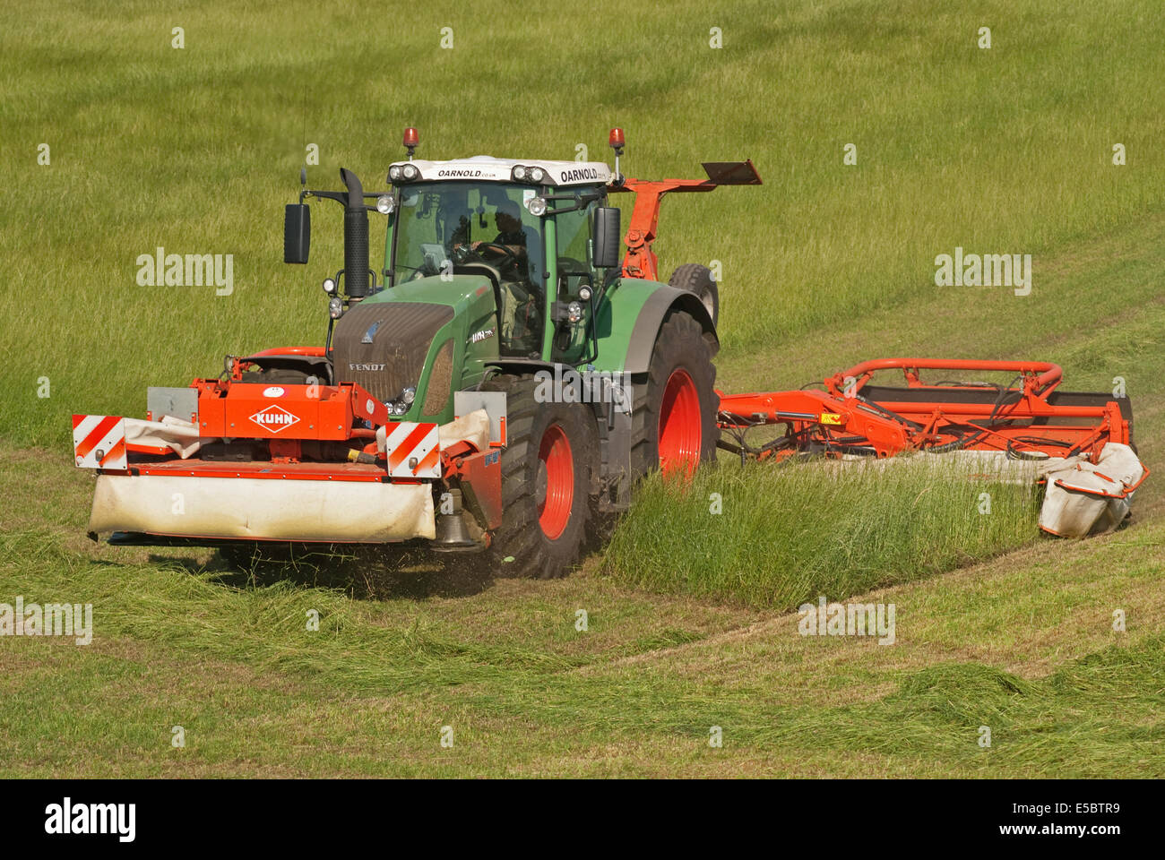 Tractor pulling grass-cutter cutting grass for making hay Stock Photo ...