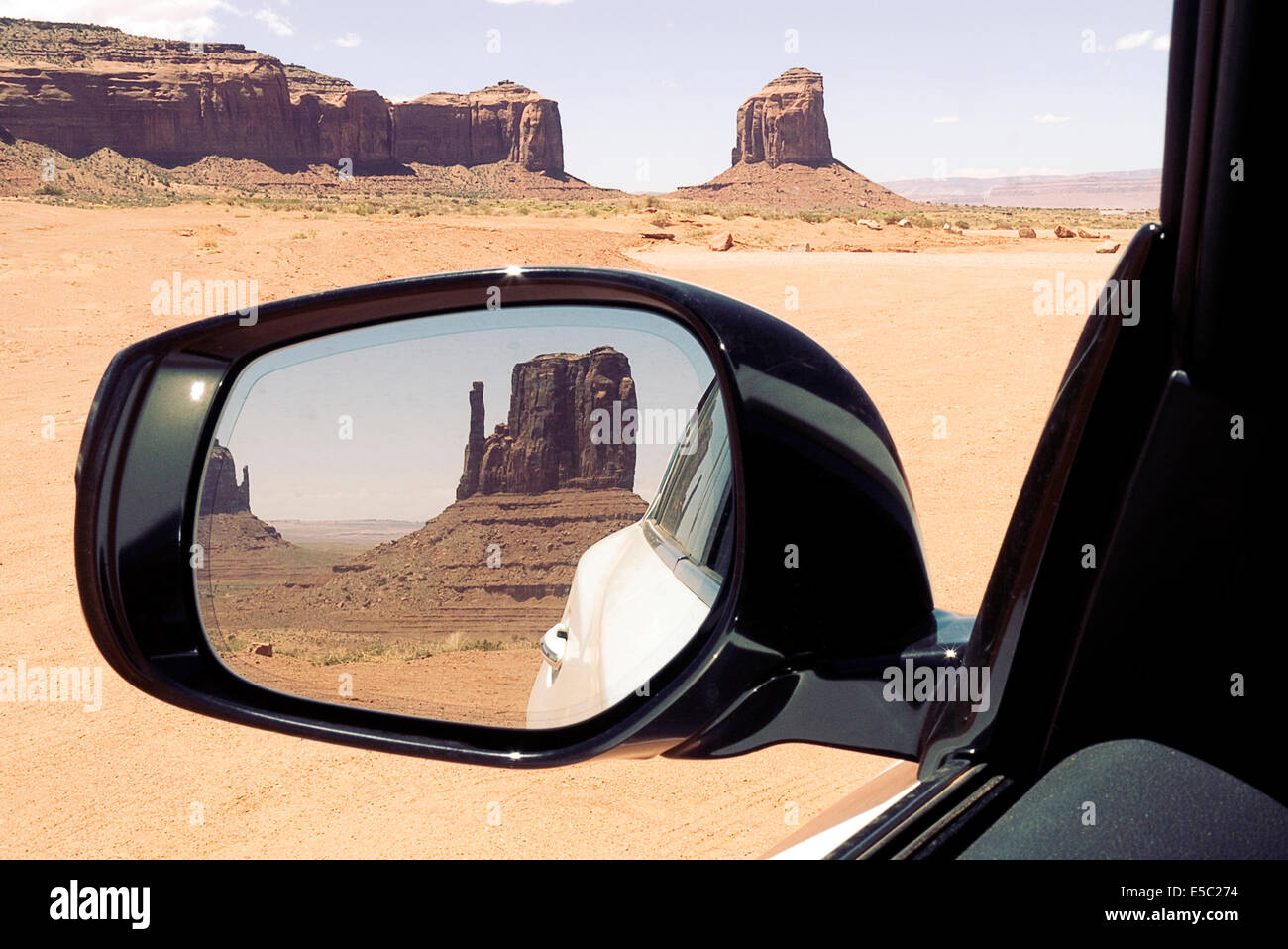 View in automobile side mirror on a drive through Monument Valley ...