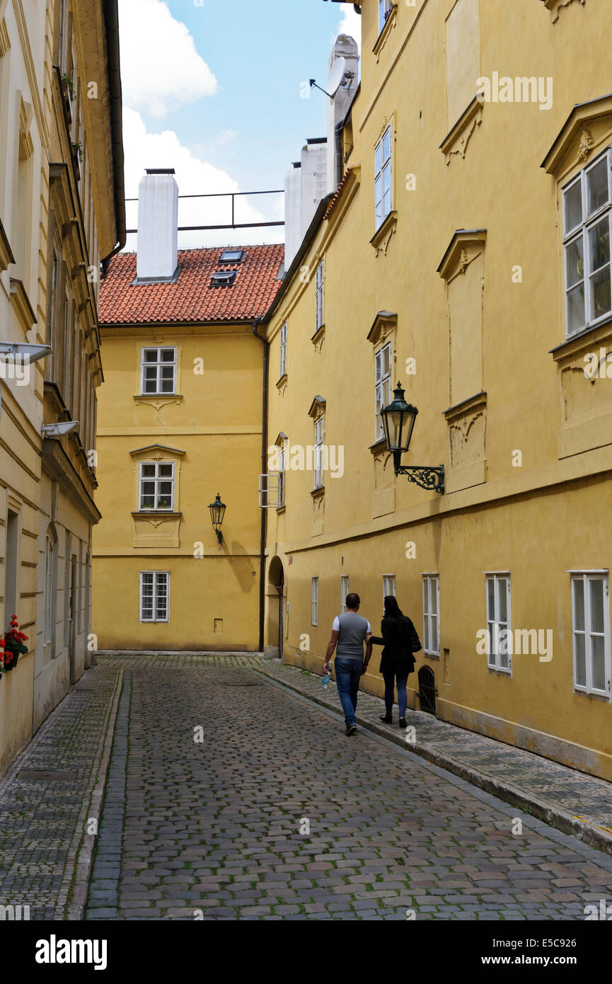 A couple walking in a deserted cobblestone street with traditional ...
