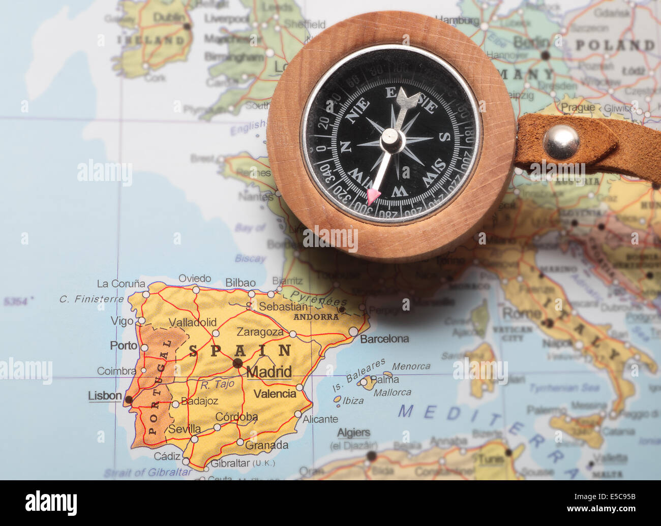 Compass on a map pointing at Spain and planning a travel destination ...